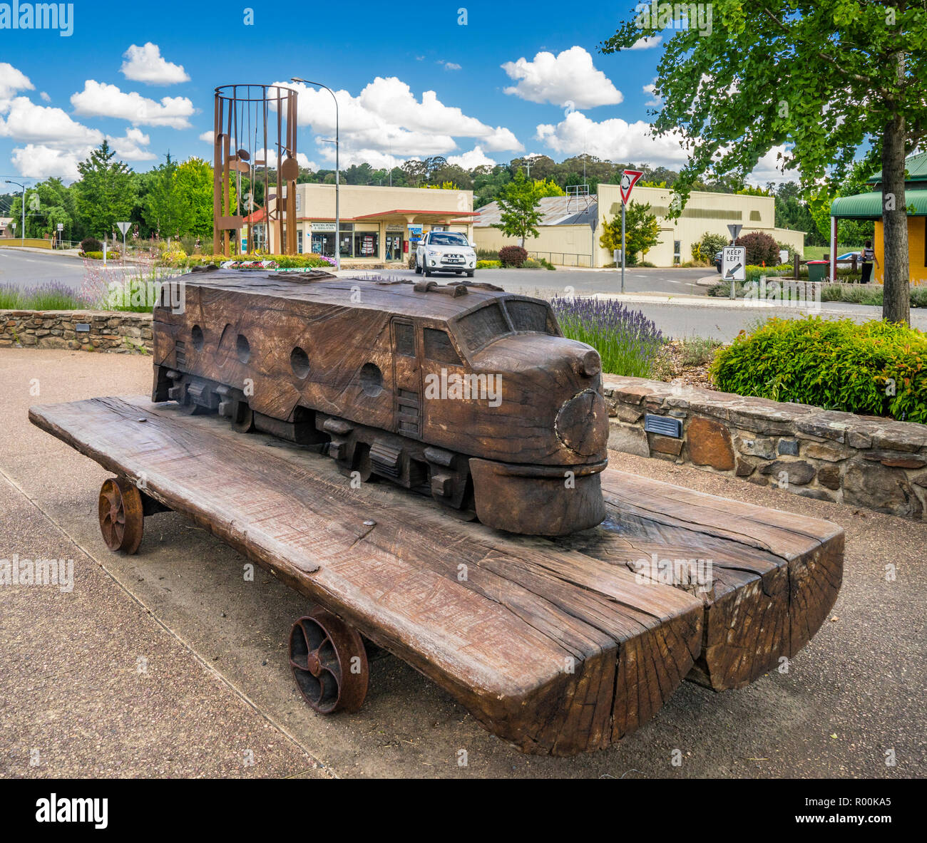 wood carved bench representing train made from blue gum, titled 'All ...