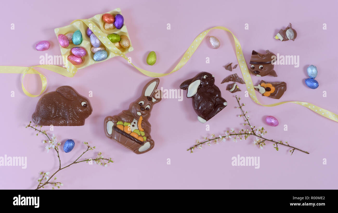 Easter chocolates composition with eggs and rabbits on pastel pink ...