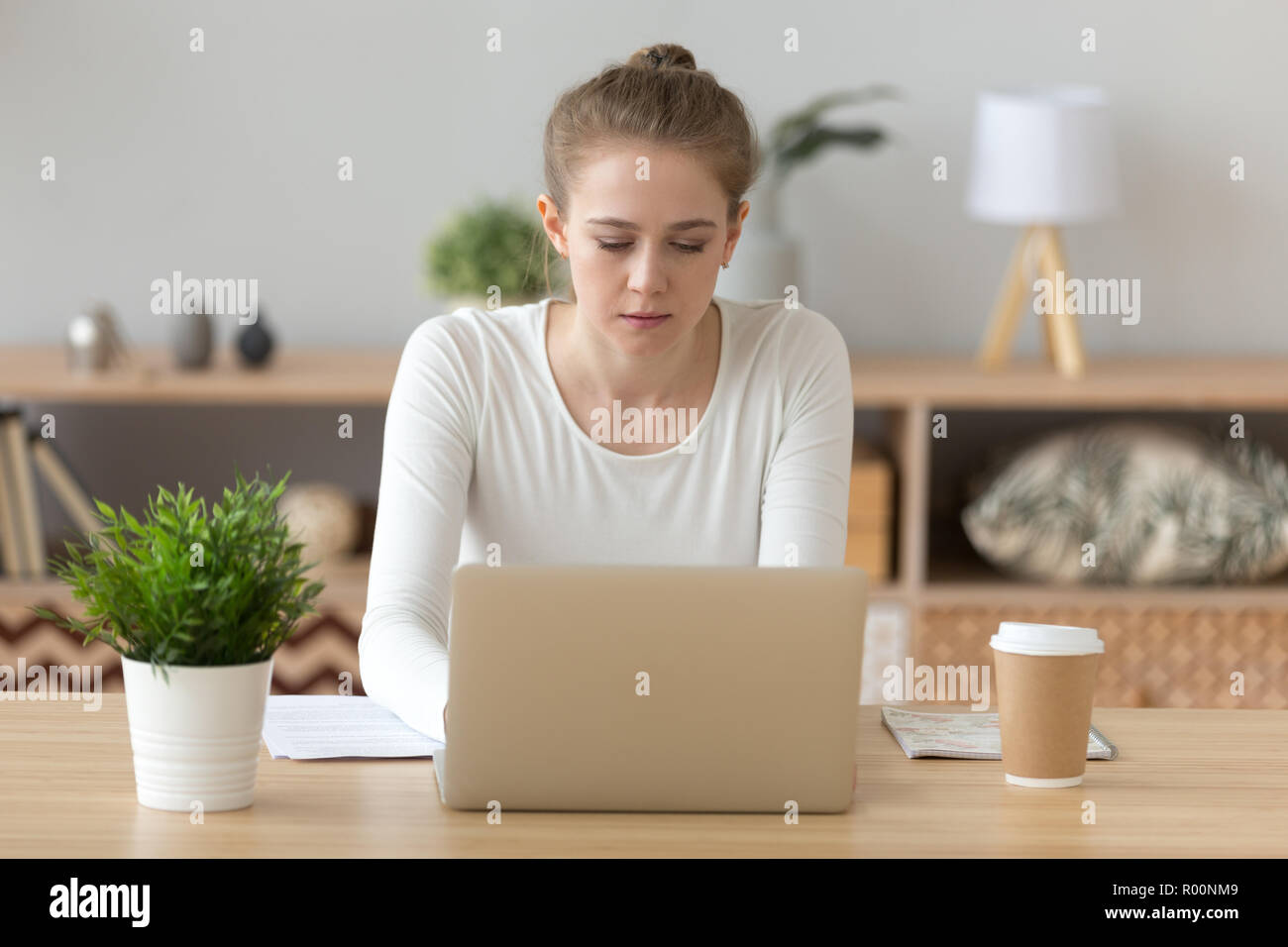 Young woman sitting at the desk using computer Stock Photo - Alamy