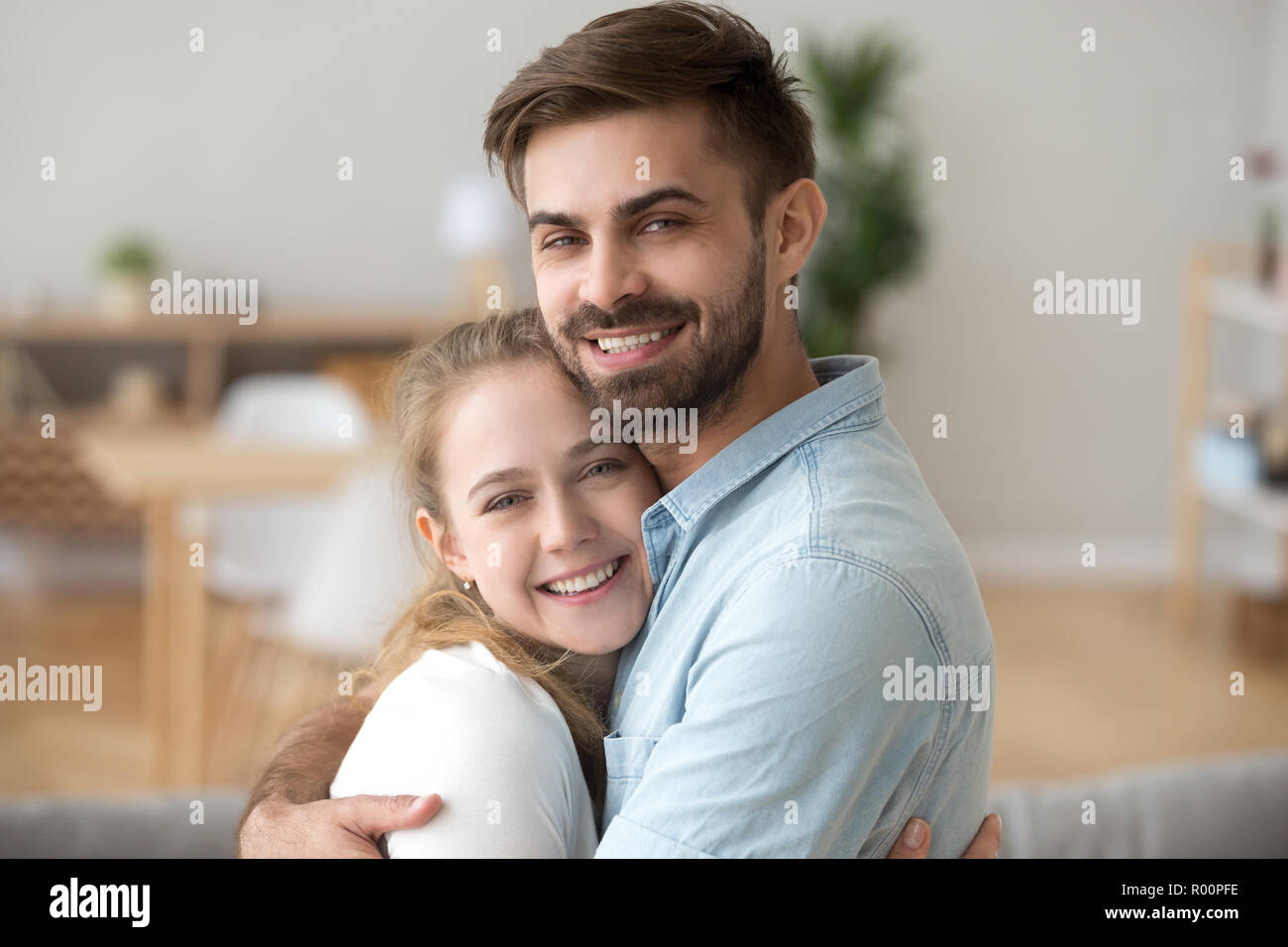 Pretty millennial just a married couple embracing indoors Stock Photo ...