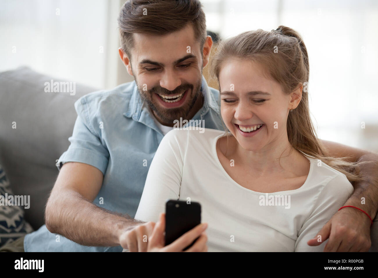 Laughing couple sitting on couch hi-res stock photography and images ...