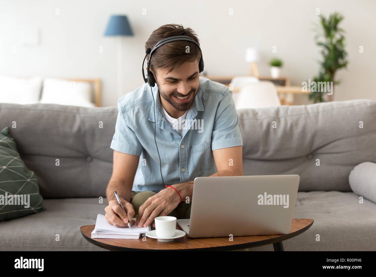 Man studying listening audio making some notes Stock Photo - Alamy