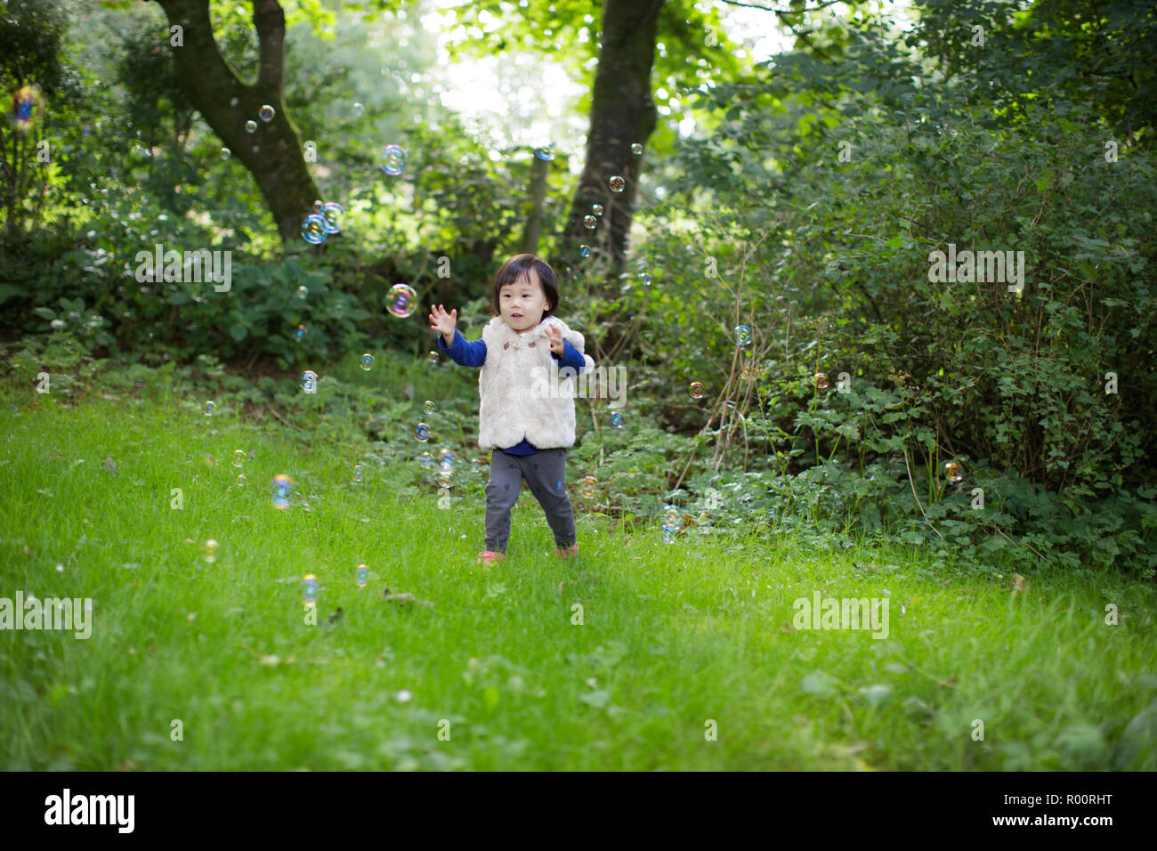 baby girl play bubble at Spring garden Stock Photo - Alamy