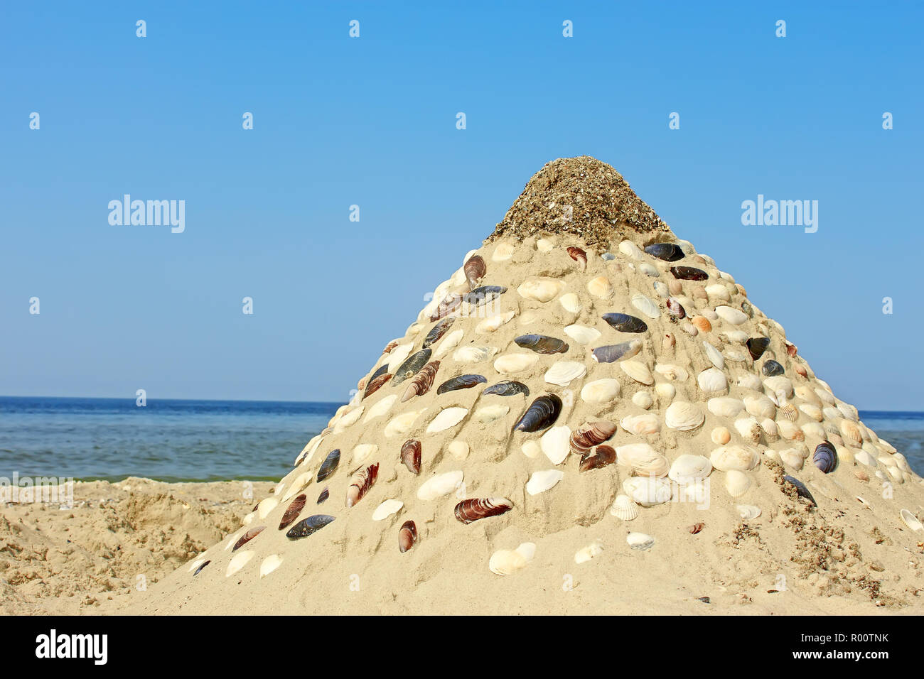Pyramid of sand and shells on the sea beach Stock Photo - Alamy
