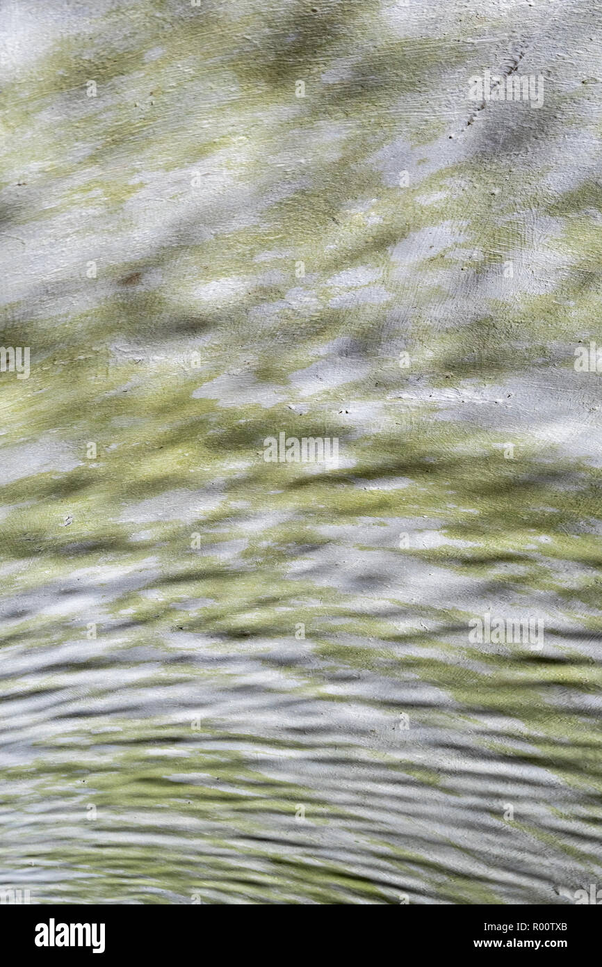 Rather abstract image of water ripples reflected on curved skimmed ...