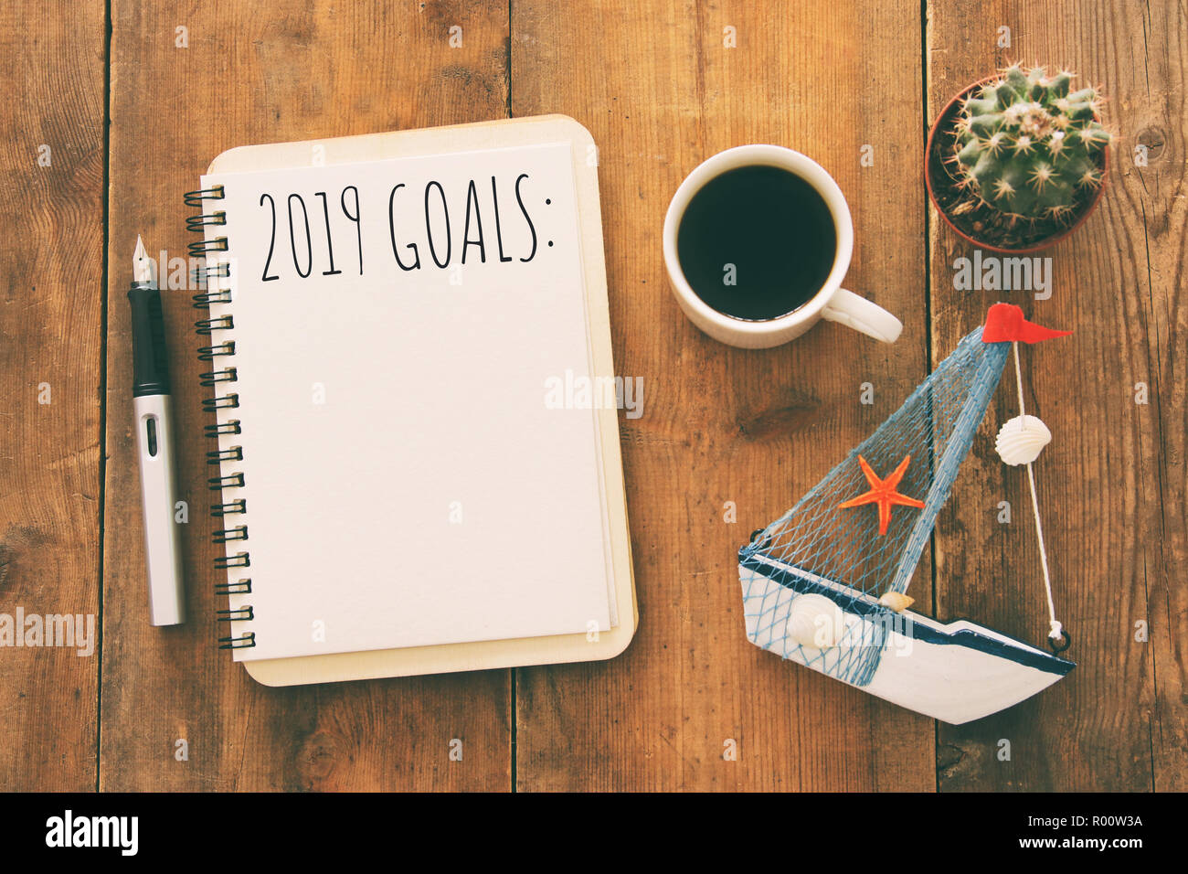 Top view 2019 goals list with notebook, cup of coffee over wooden desk ...