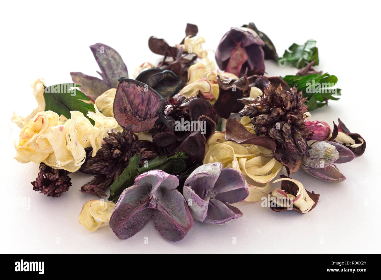 Purple and pale yellow potpourri loosely arranged on a white surface ...