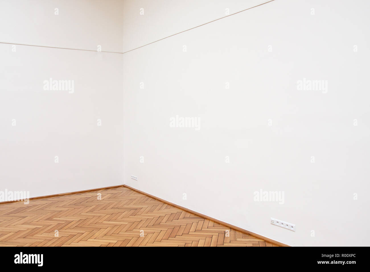 Corner of a large white wall with wooden floor tiles Stock Photo - Alamy