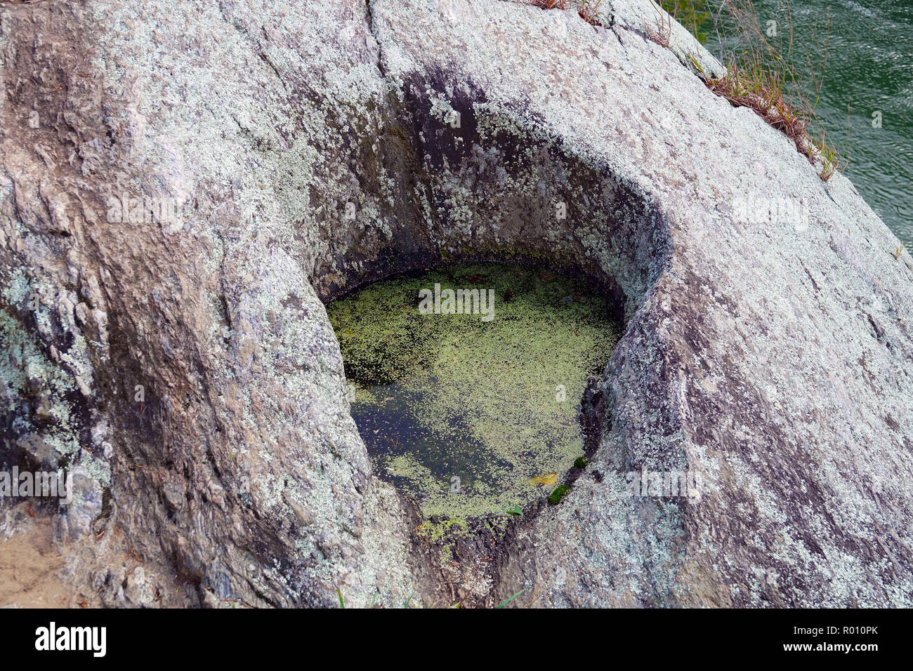 closeup of water filled pot hole with floating algae along the Billy ...