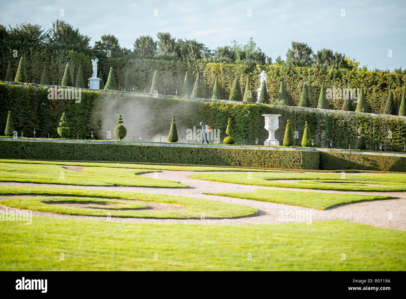 Versailles garden with beautiful sculptures, vases and trimmed bushes ...