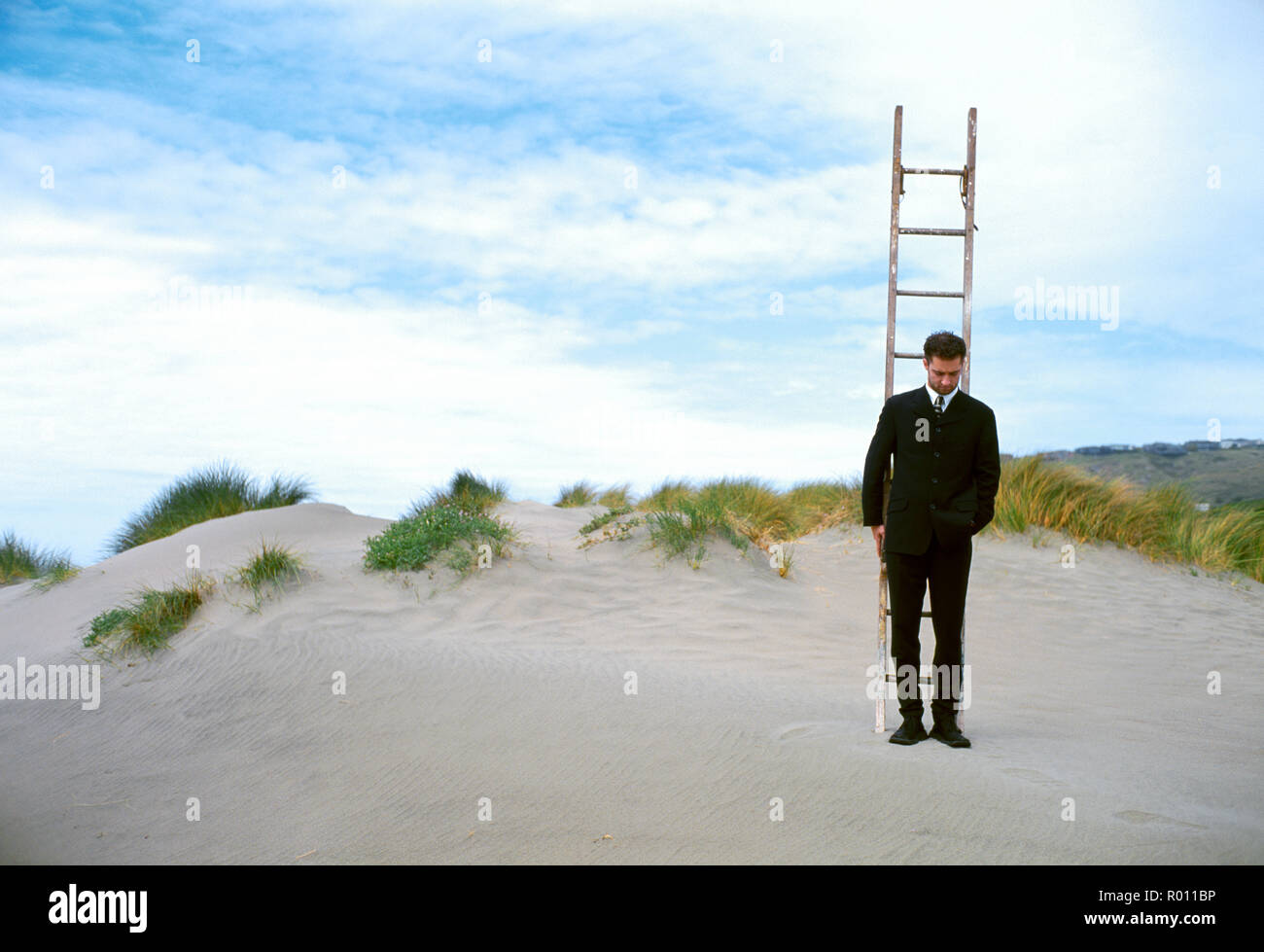 Man standing with ladder on beach Stock Photo - Alamy