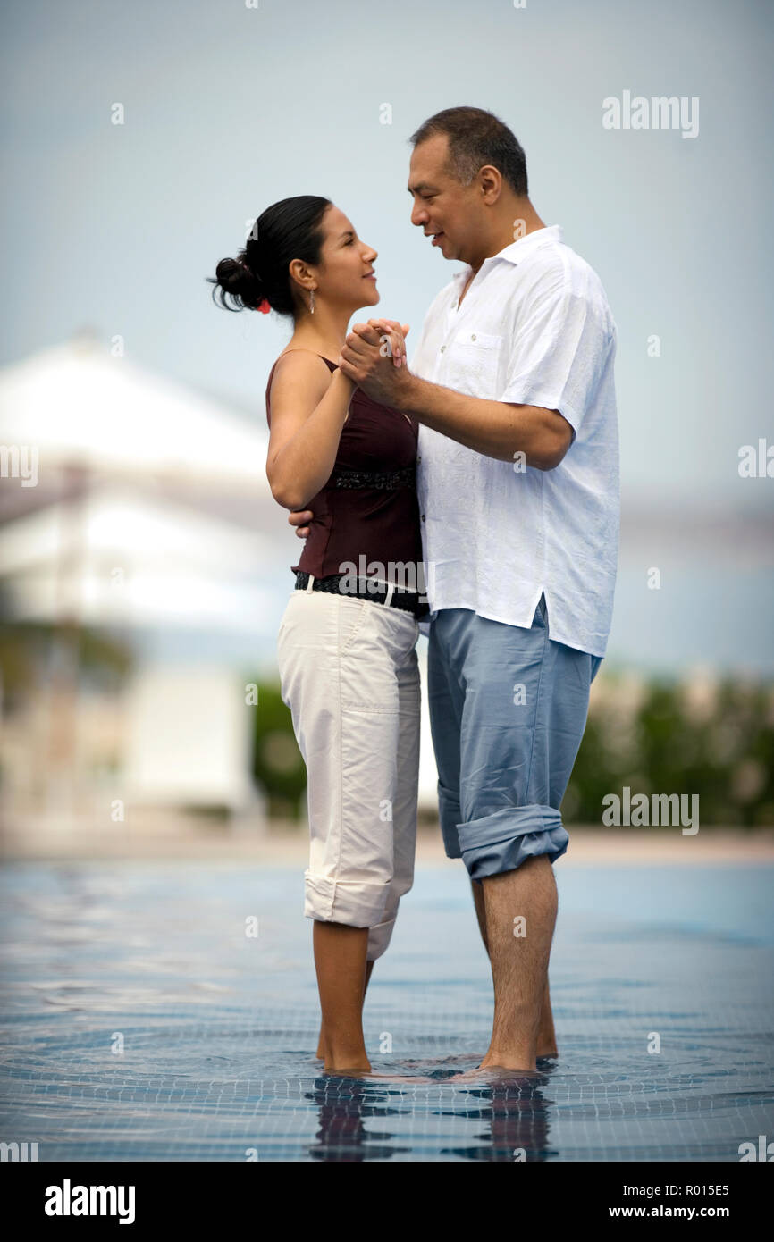 A couple is seen dancing in the swimming pool during the day Stock ...