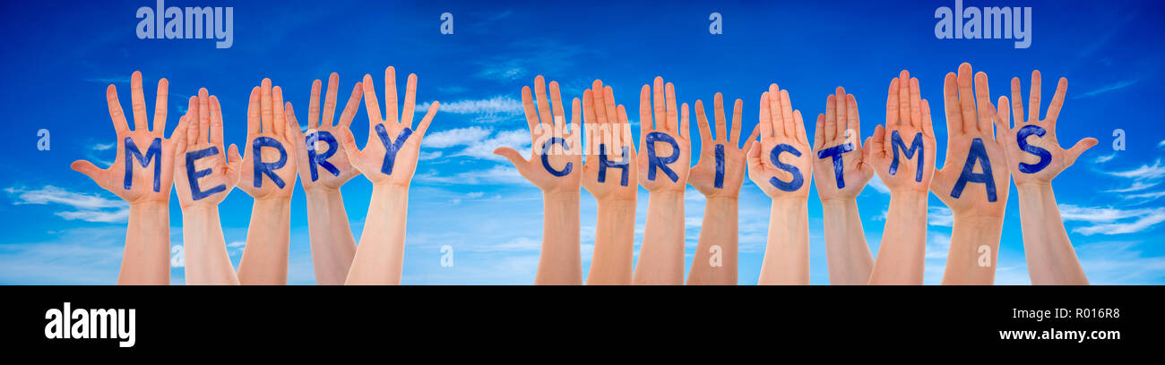 Many Hands Building Word Merry Christmas, Blue Sky Stock Photo - Alamy