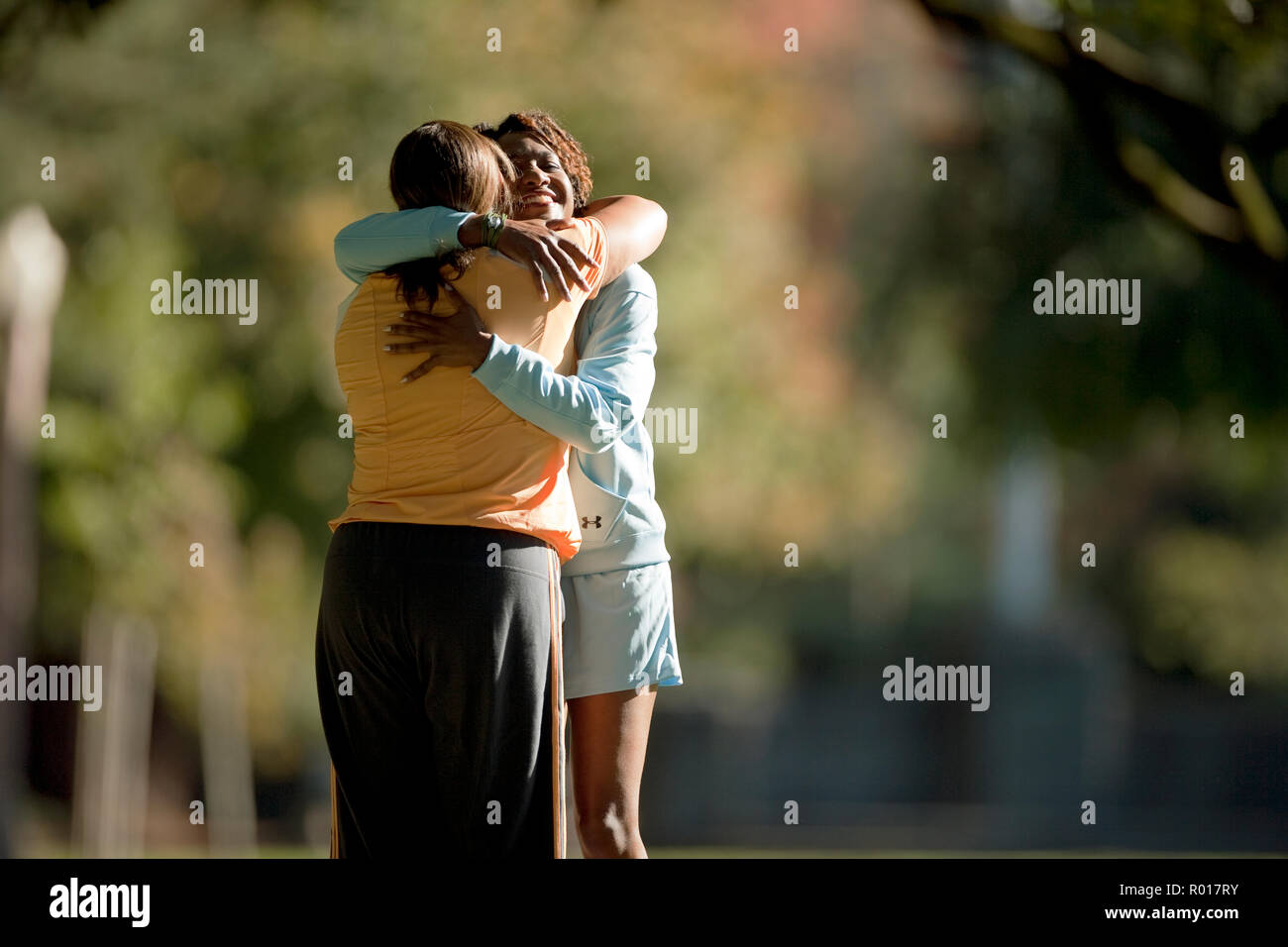 Two women embracing in park Stock Photo - Alamy