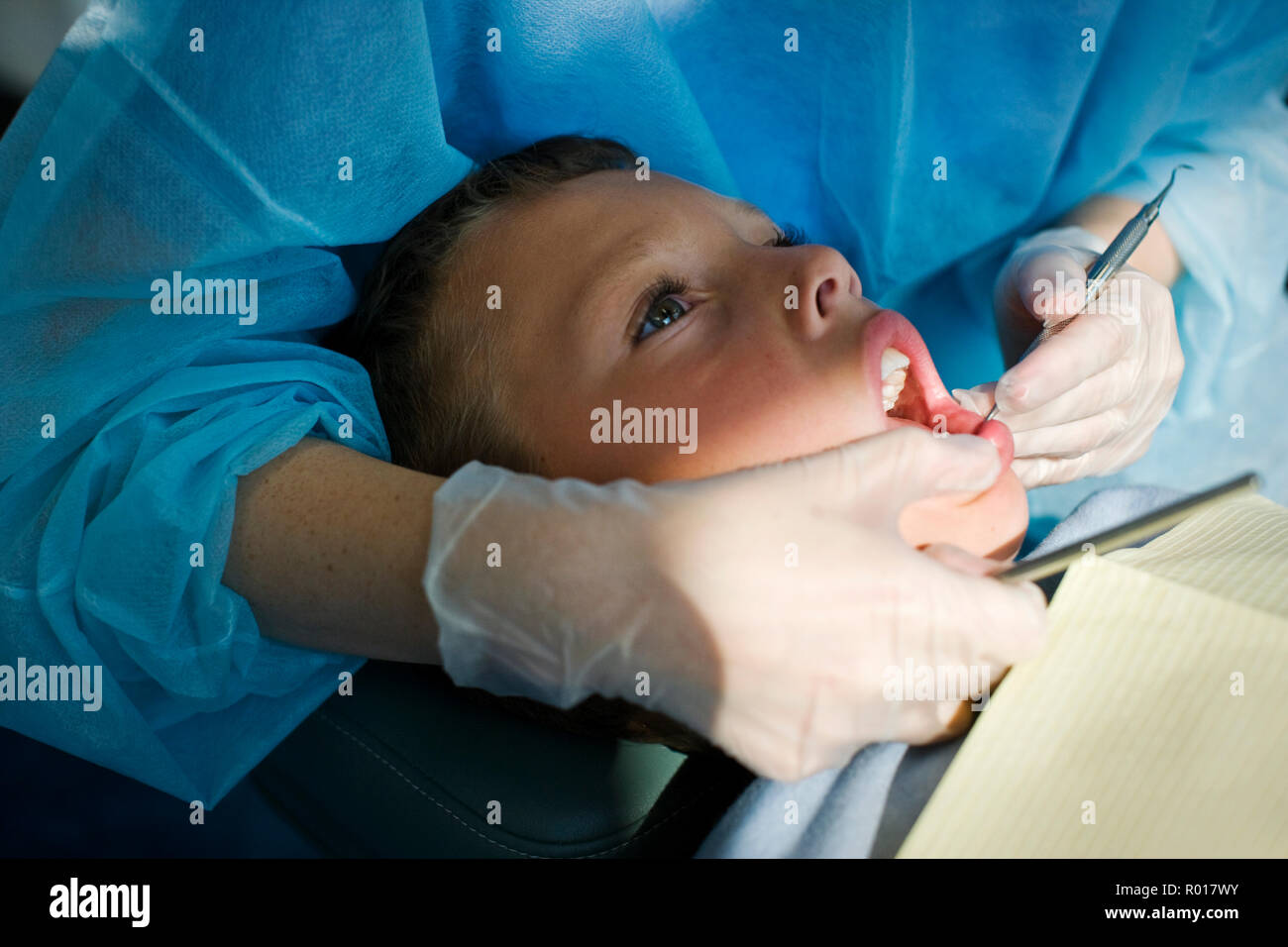 Boy getting teeth examined by the dentist Stock Photo - Alamy