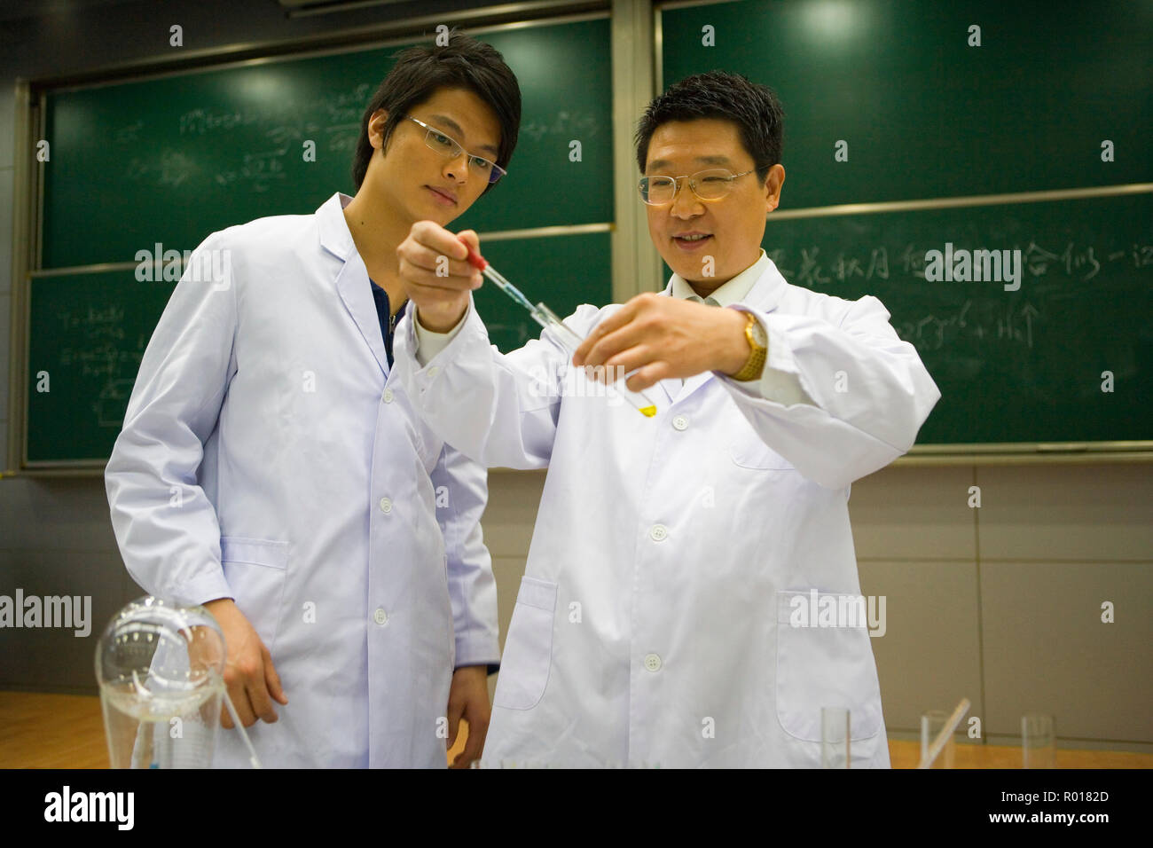 Teenage boy in science class with his mid-adult teacher Stock Photo - Alamy