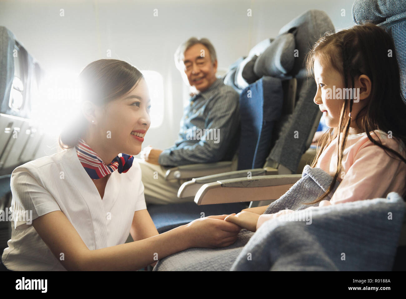Flight attendants and passengers on the plane Stock Photo - Alamy