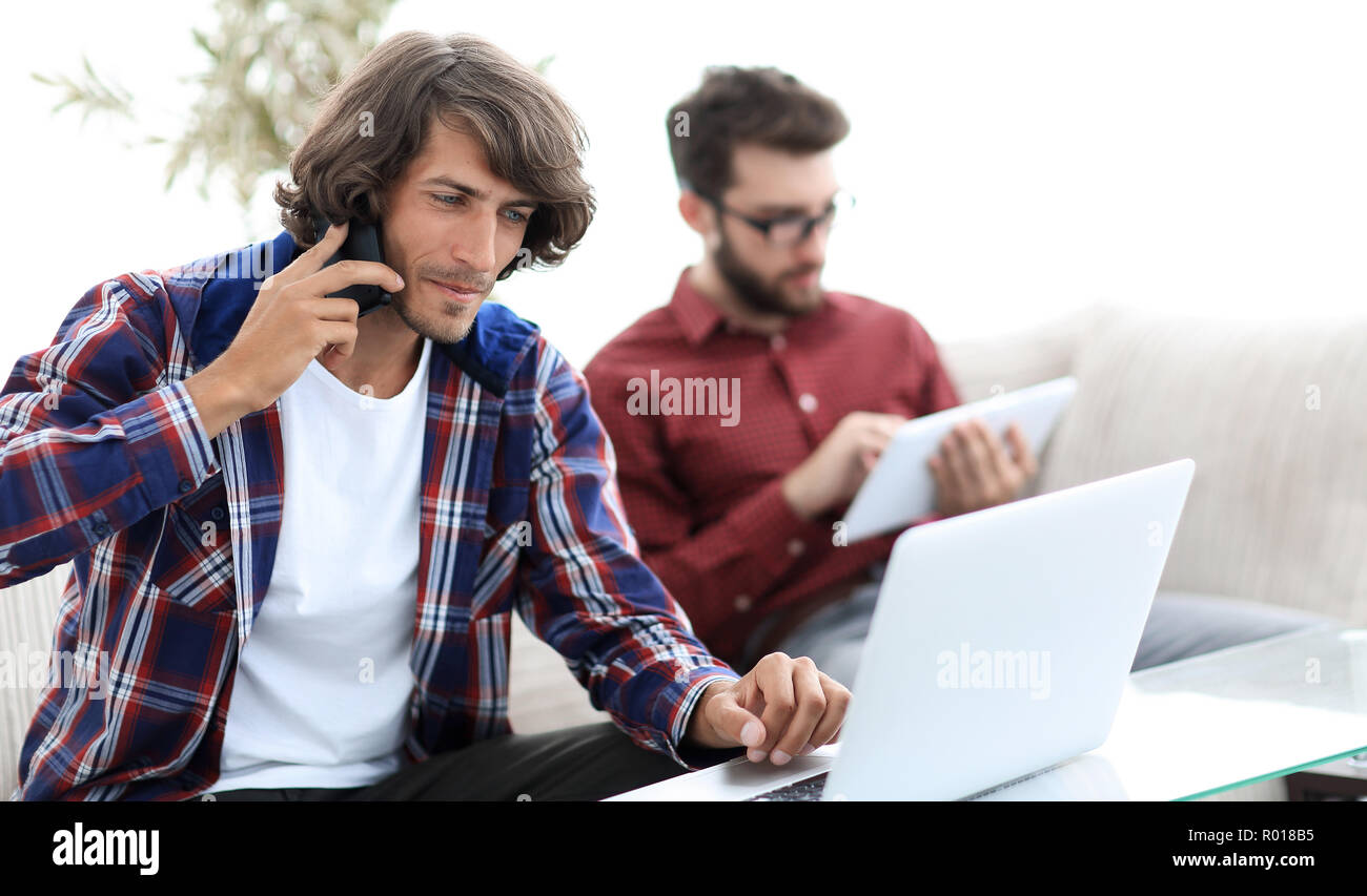 guy with a friend sitting at the desk Stock Photo - Alamy