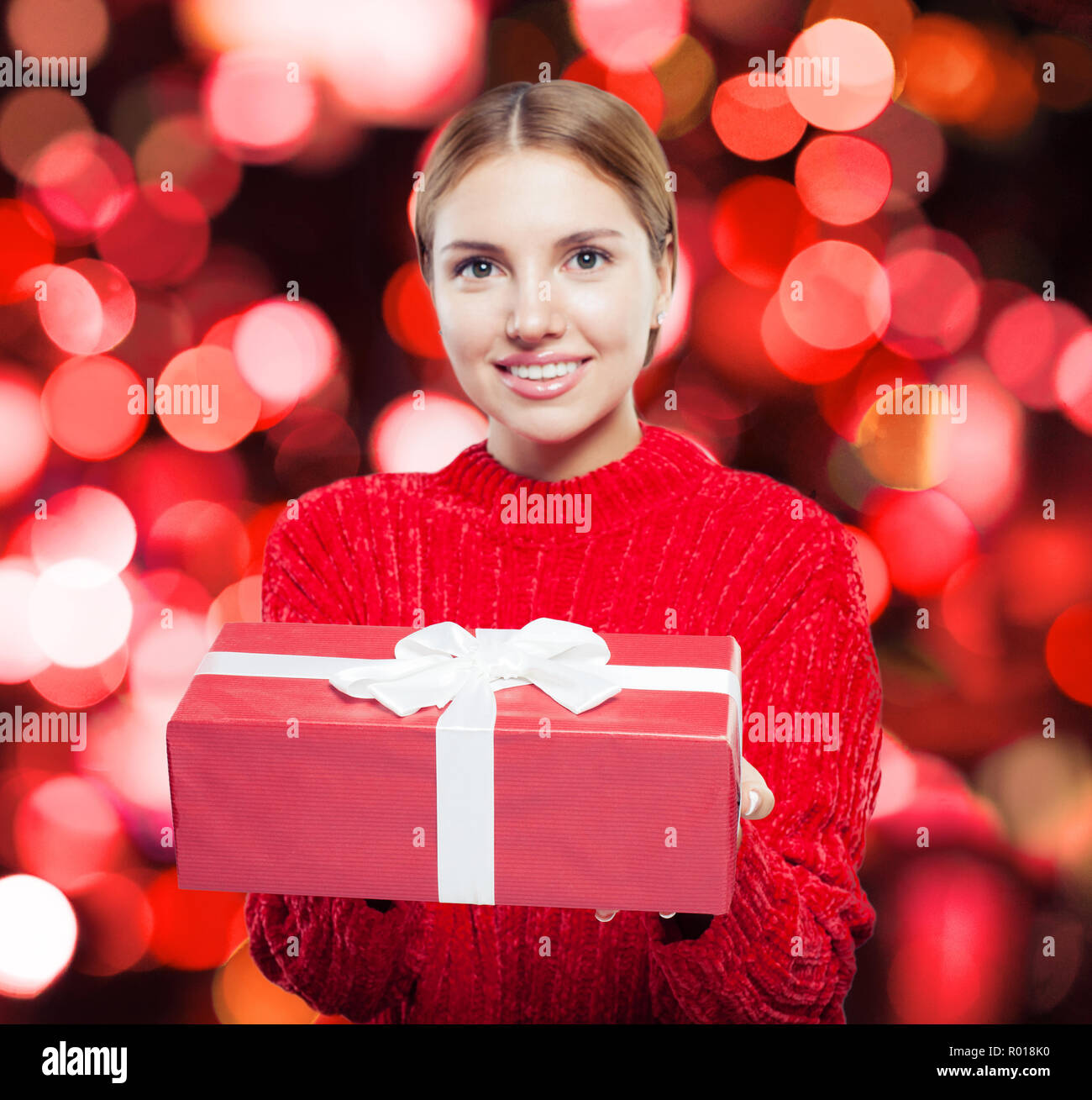 Red gift with white silky ribbon in female hand on party glitter ...