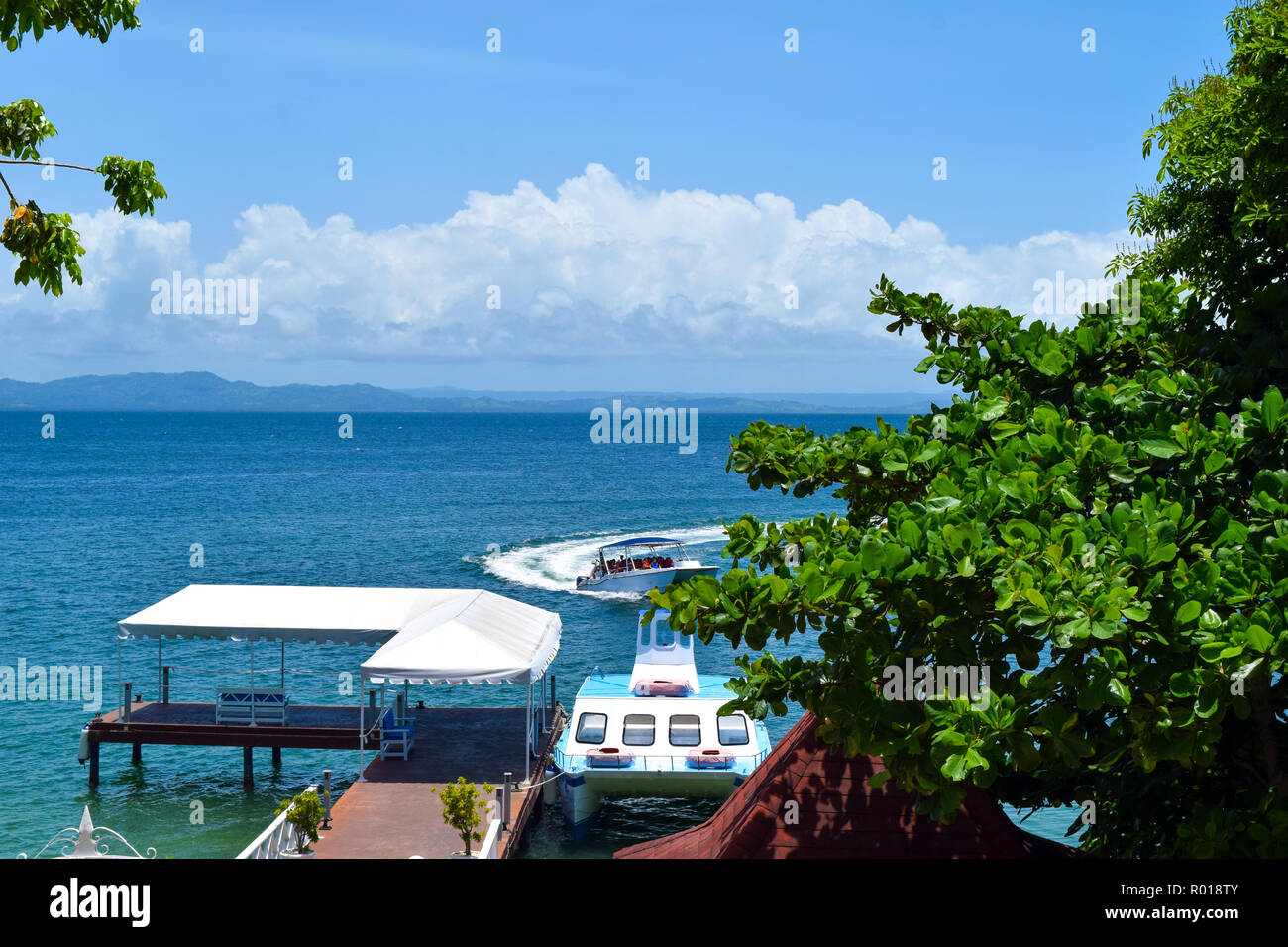 View over dock in caribbean sea, boat is arriving at pier Stock Photo ...