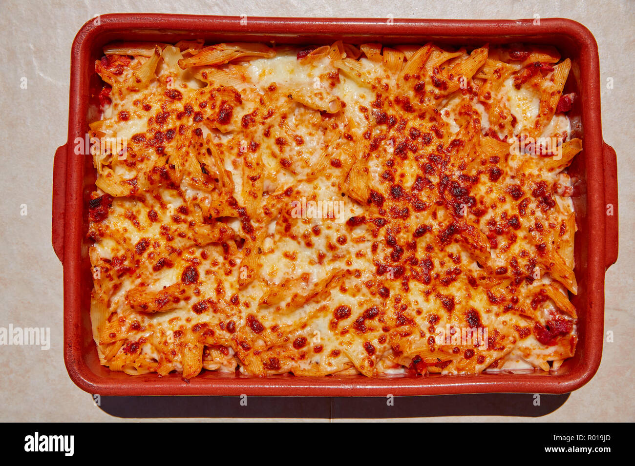 Bolognese macaroni gratinated with cheese in a clay pot Stock Photo - Alamy