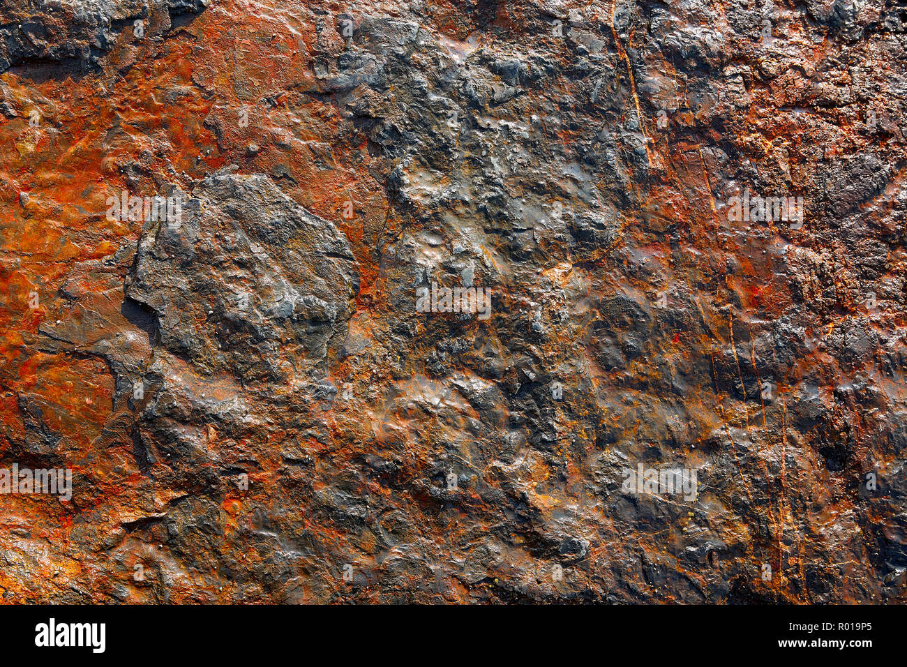 Stone texture in the beach shore with red oxide Stock Photo - Alamy