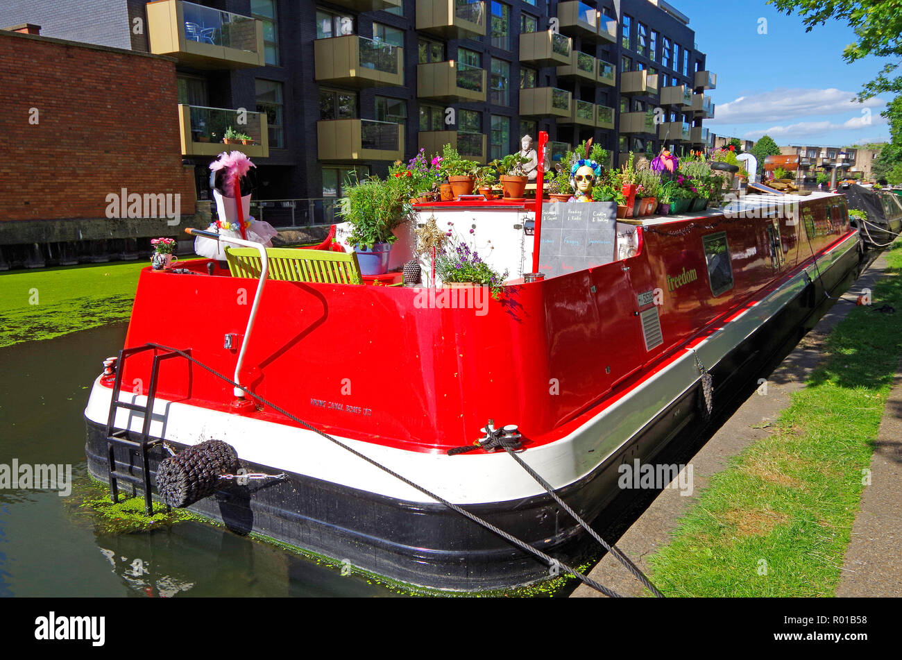 Large red barge, the Freedom, with extensive garden of tubs on its roof ...
