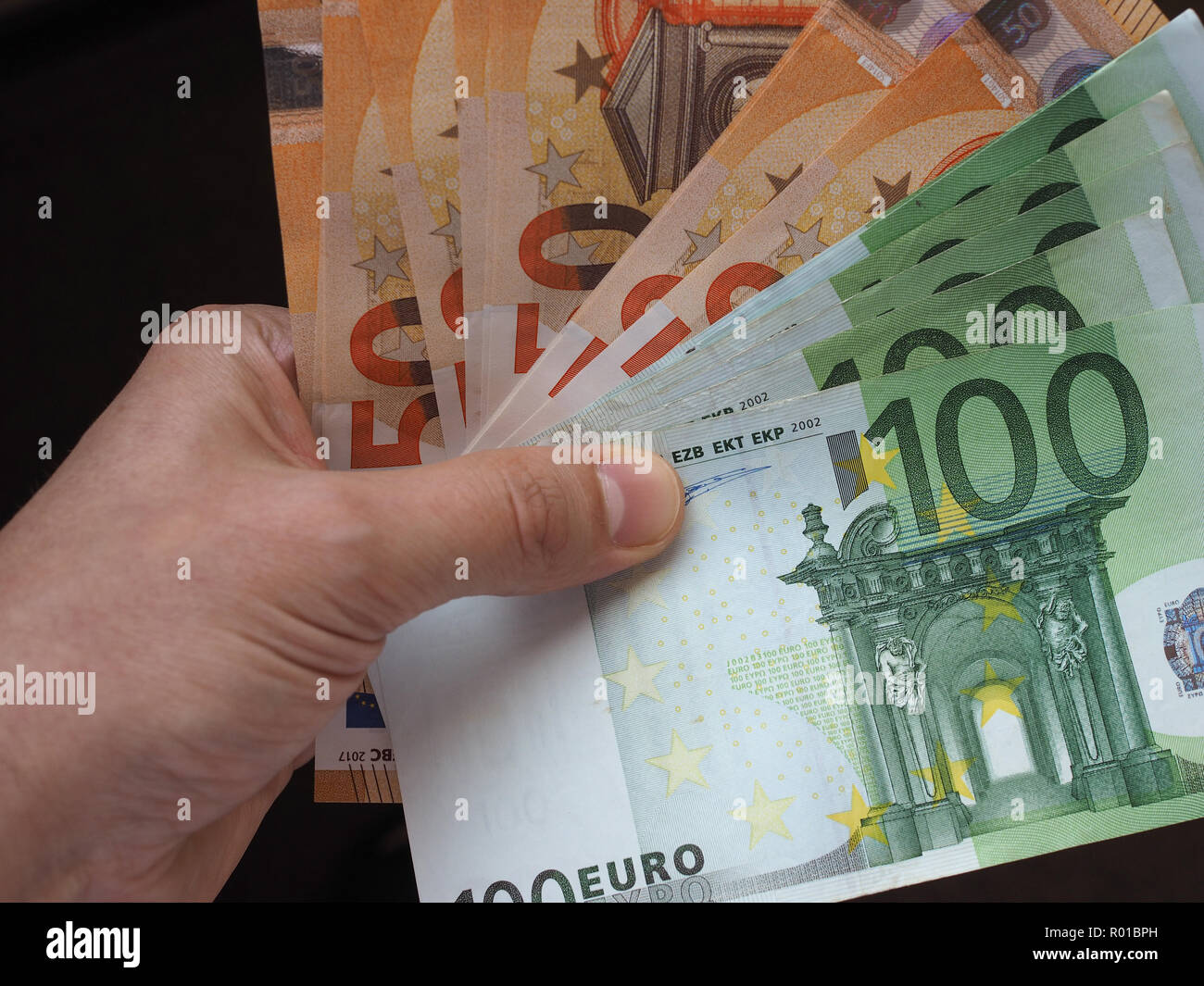 Hand holding and giving Euro banknotes money (EUR), currency of ...