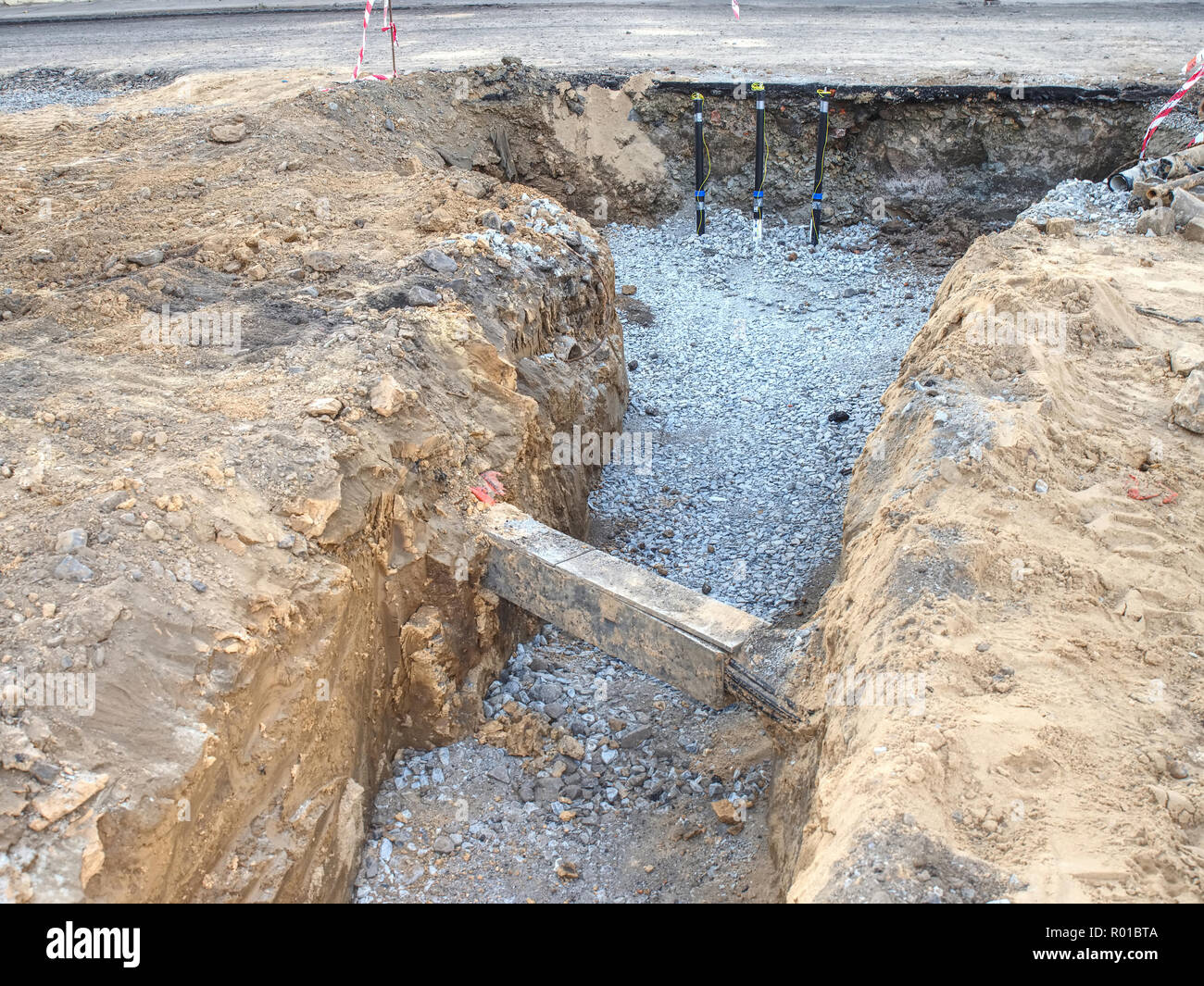 Underground crossing of town and houses utilities under pavement. Tubes ...