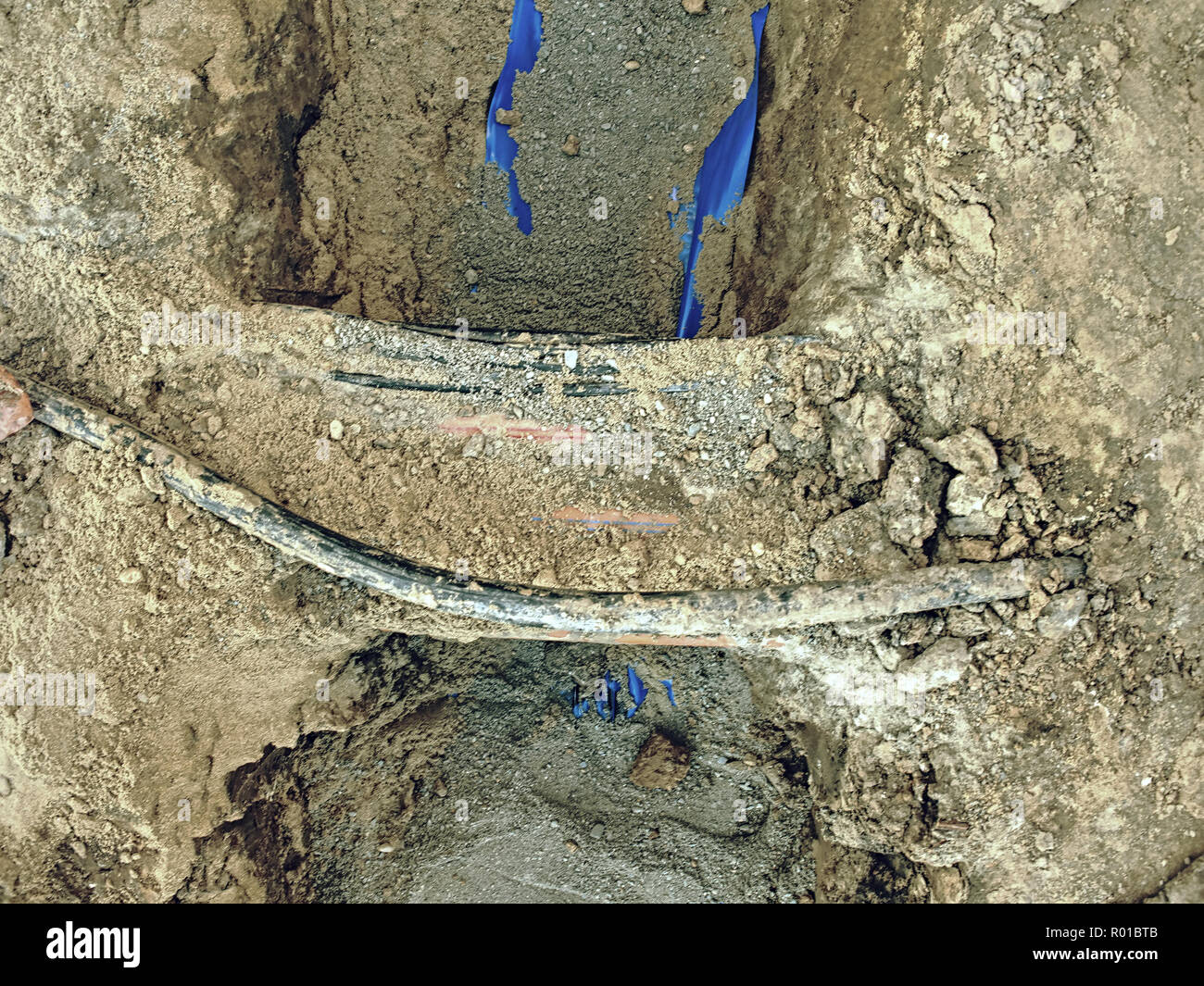 Pipe and cables in trench at road crossing laying pipelines. Building ...