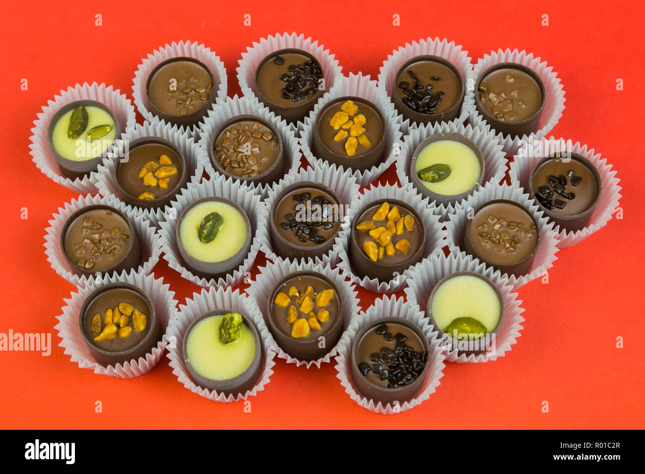 Chocolate candies with various fillings in a paper wrapper on a bright ...