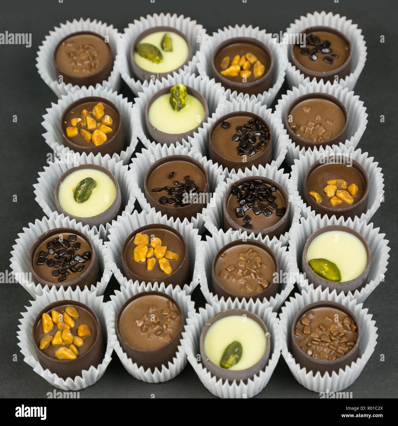 Chocolate candies with various fillings in a paper wrapper on a bright ...