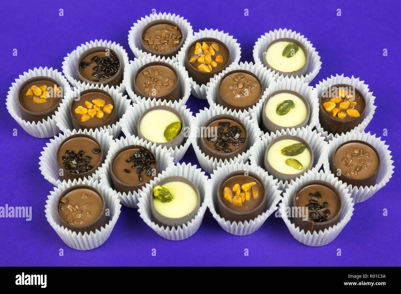 Chocolate candies with various fillings in a paper wrapper on a bright ...