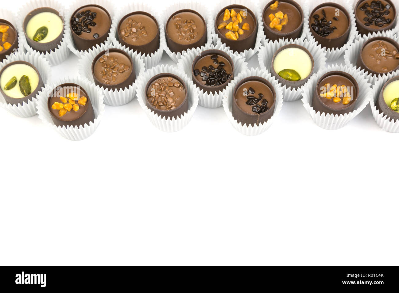 Chocolate candies in paper packaging on a white background Stock Photo ...