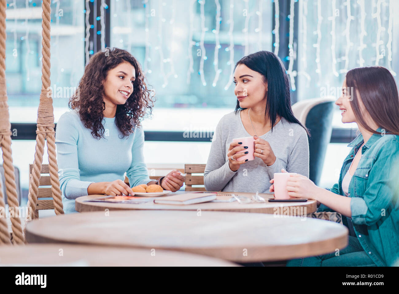 Nice female friends talking to each other Stock Photo - Alamy