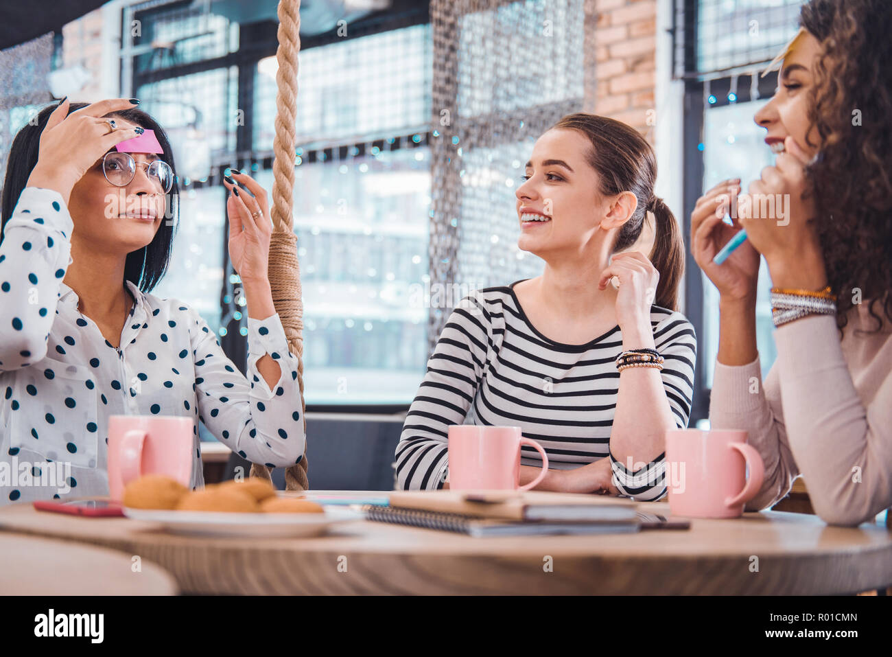 Nice smart woman playing a guessing game with friend Stock Photo - Alamy