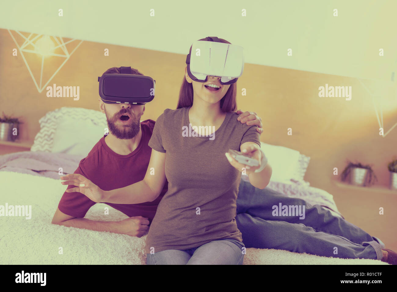 Cheerful couple watching TV in visual reality glasses Stock Photo - Alamy