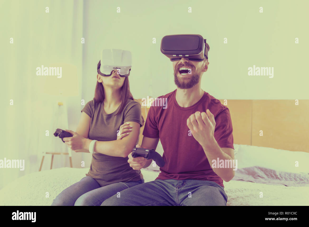 Cheerful girl beating her friend in video games Stock Photo - Alamy