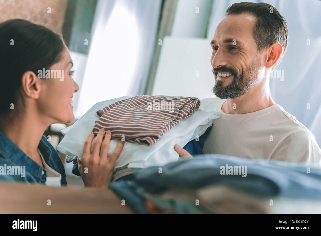 Pleased male person helping his wife Stock Photo - Alamy