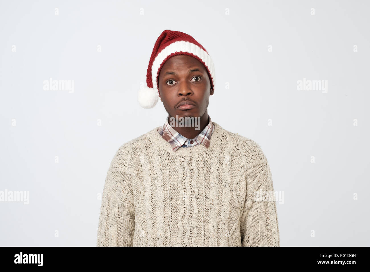 Sad and lonely mature african man in Santa Claus hat over white ...