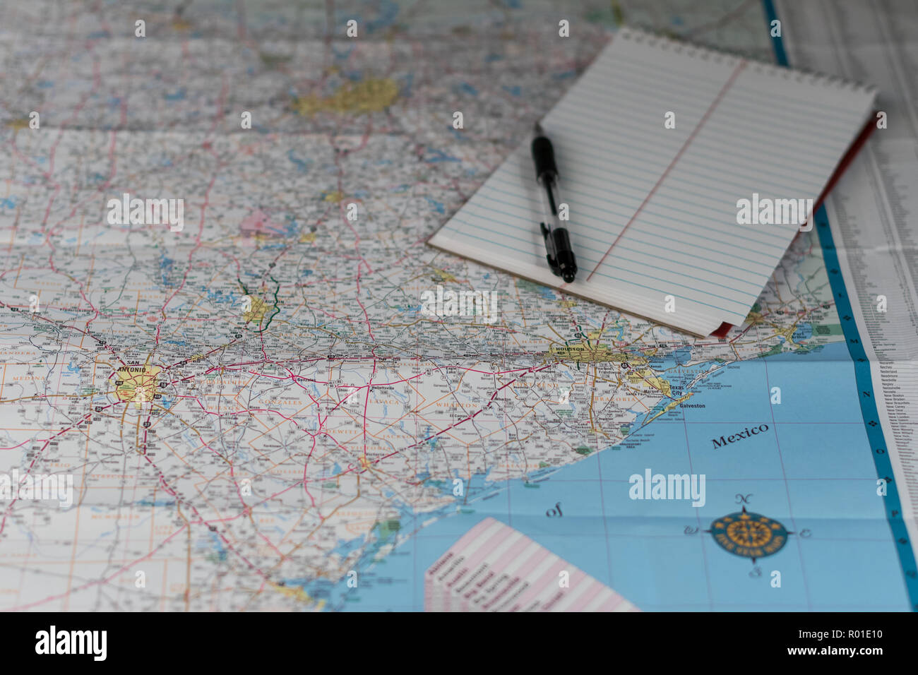 Still life scene of a map, notebook, and pen for planning a vacation ...