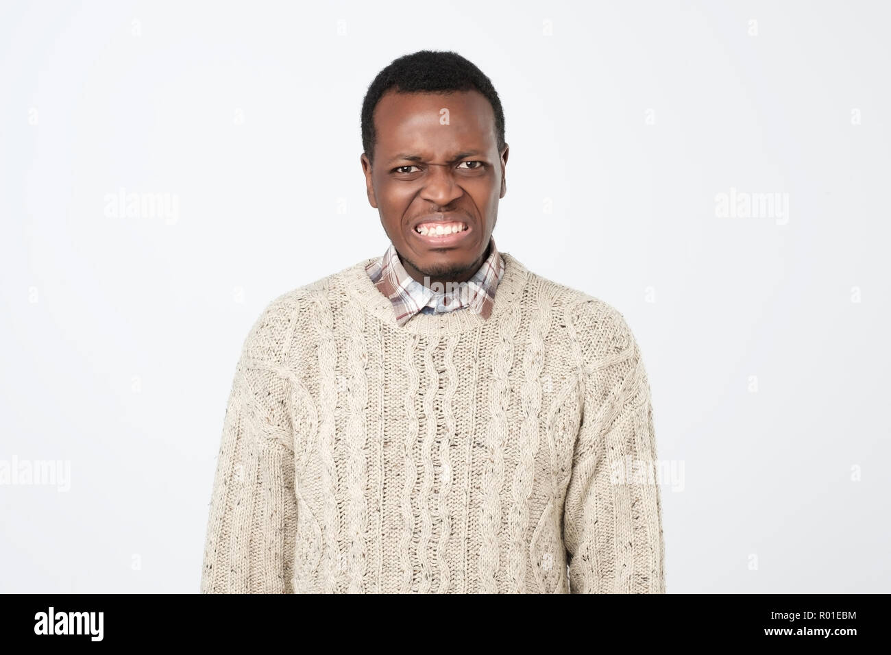 Displeased african man frowns face with displeasure, has irritated ...