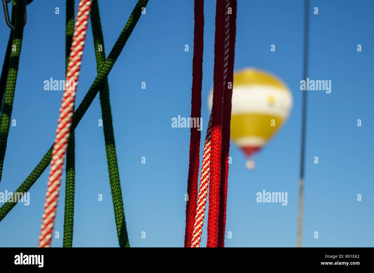 Looking through ropes of a balloon on a blurred yellow balloon in the ...