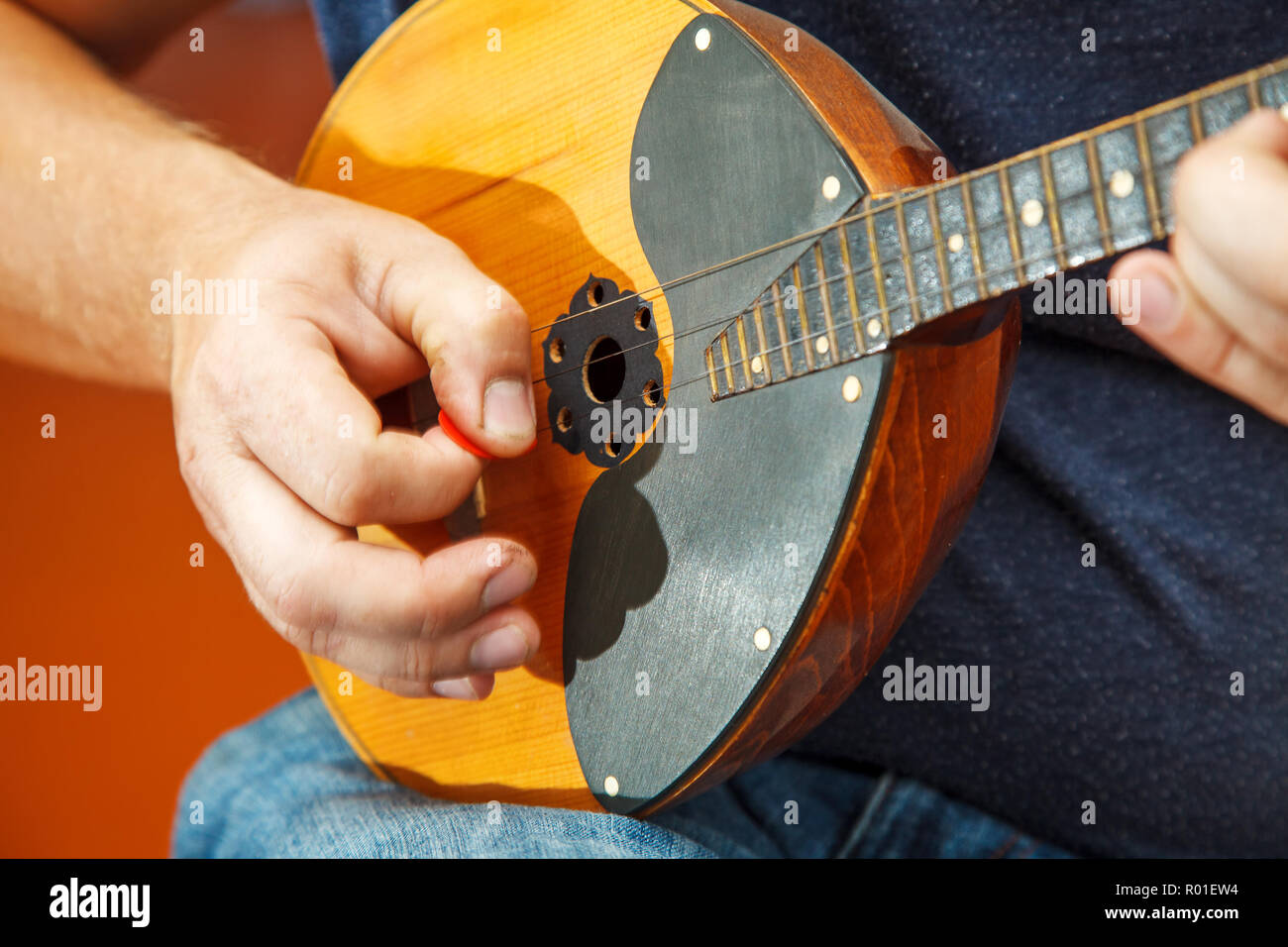 man playing the mandolin indoor with bright daylight. hands closeup ...