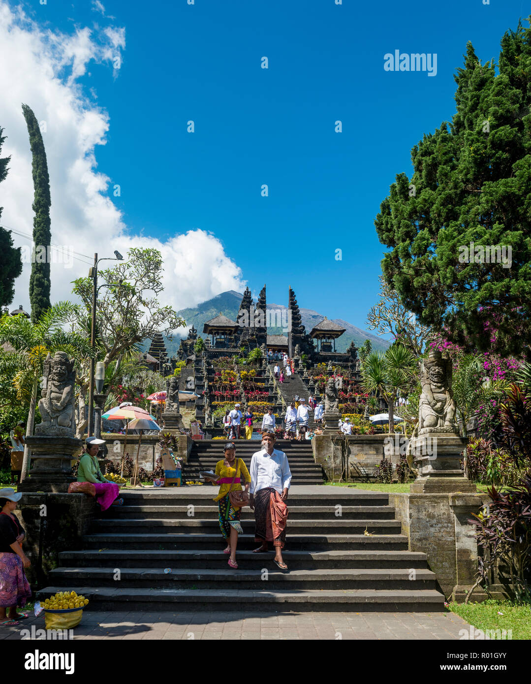 Balinese believers in traditional clothing go down stairs, split gate ...