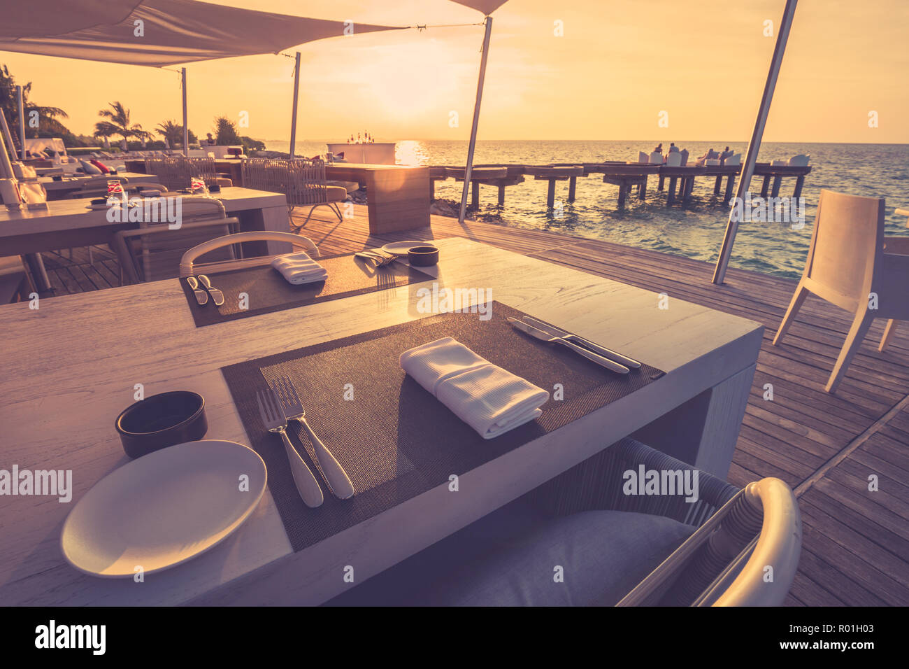Table dinner setting at the beach on twilight time in tropical ...