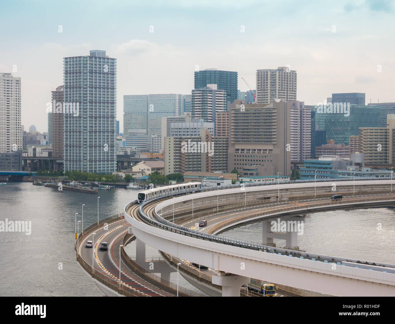 Modern highway with automobiles and train leading to a bridge. Rainbow ...