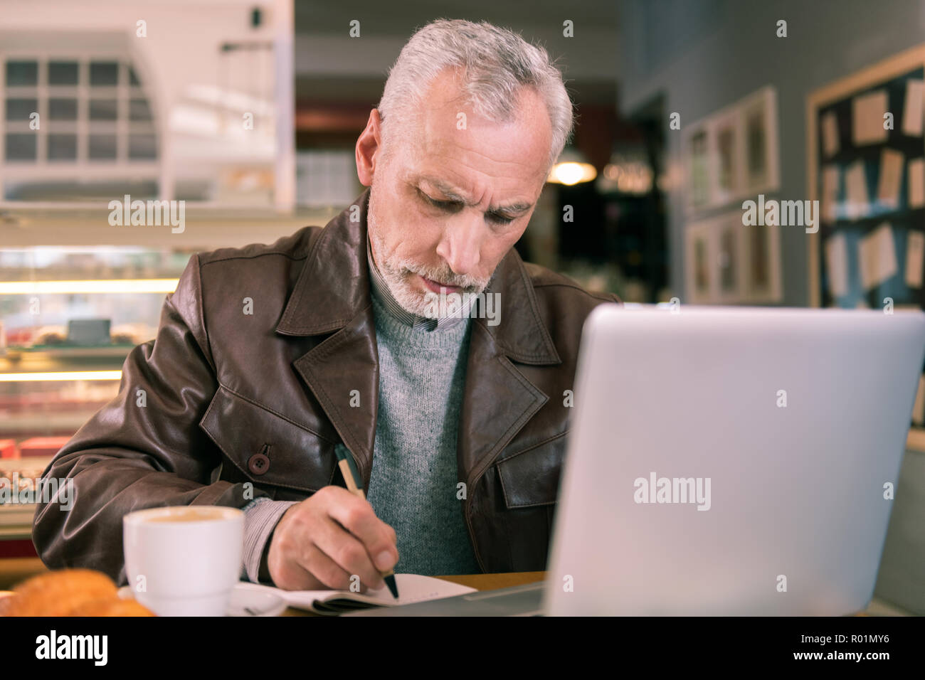 Famous inspired writer holding pencil while making notes to novel Stock ...