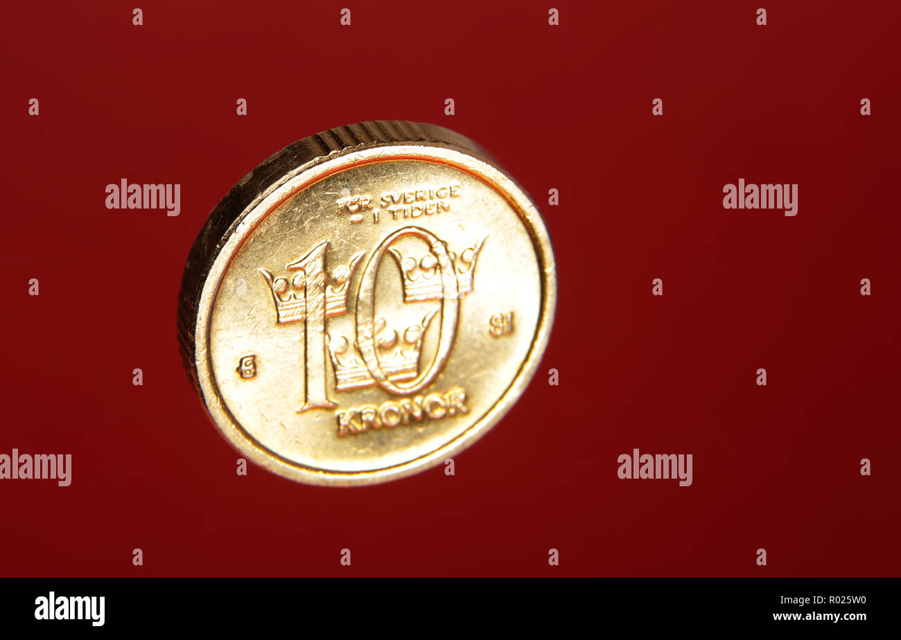 Swedish ten krona golden coin on red background Stock Photo - Alamy