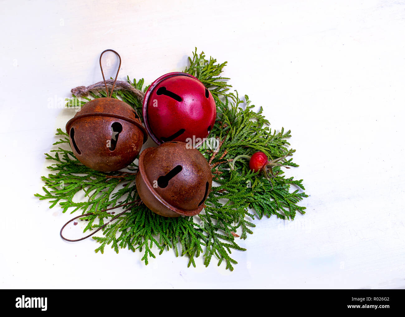 Old fashioned bells with cedar branches and rose hips Stock Photo - Alamy